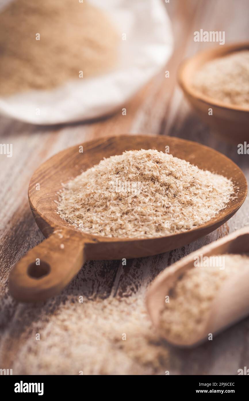 Heap of psyllium (Plantago ovata) husk in wooden bowl on wooden table ...