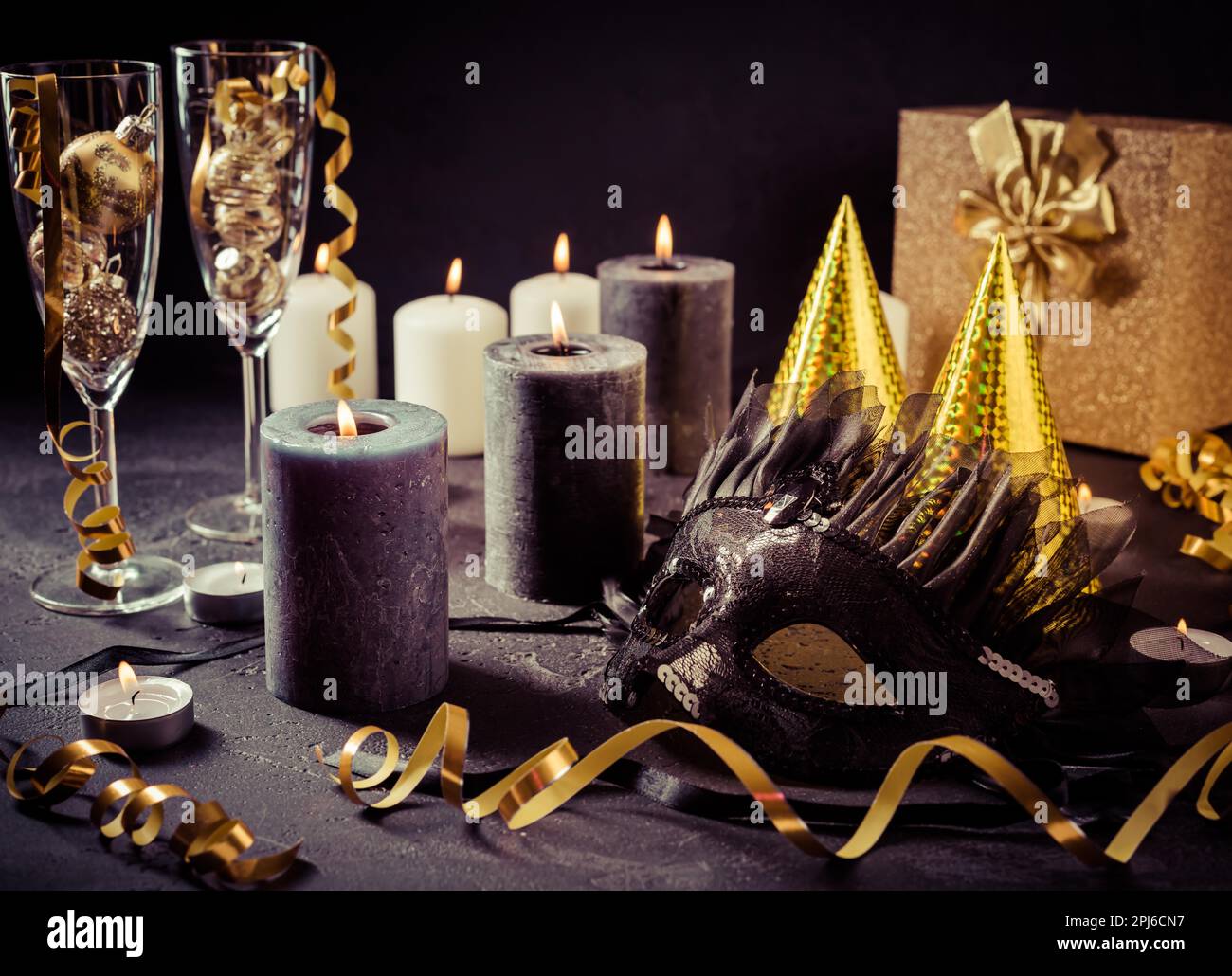Party still life with carnival mask, candles on black background Stock ...