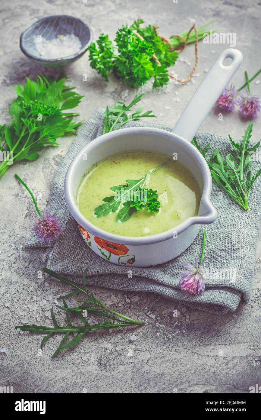 Healthy homemade green herb soup in pot made from local wild and garden ...