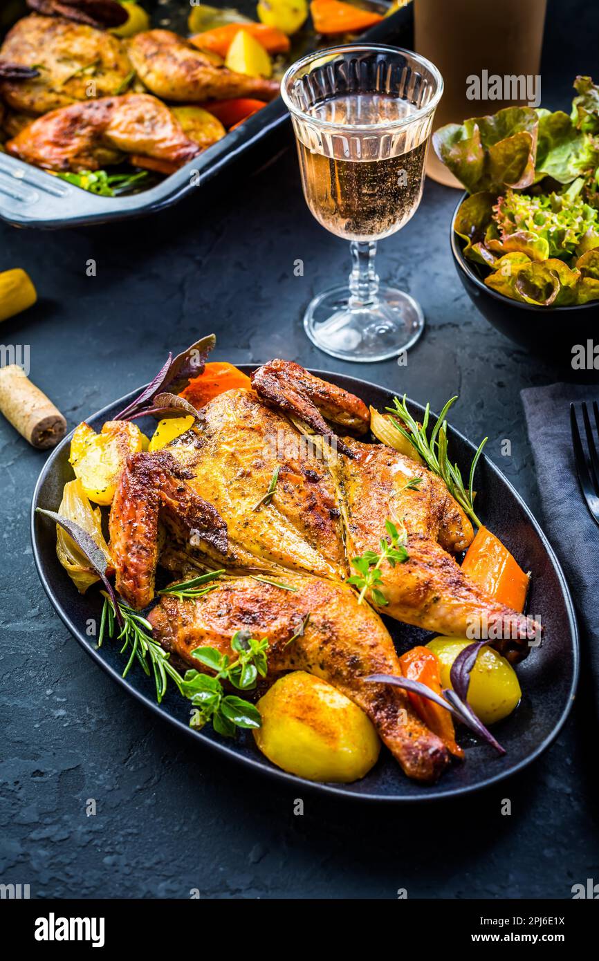 Baked whole chicken with potatoes, carrots, herbs and salt and rose ...