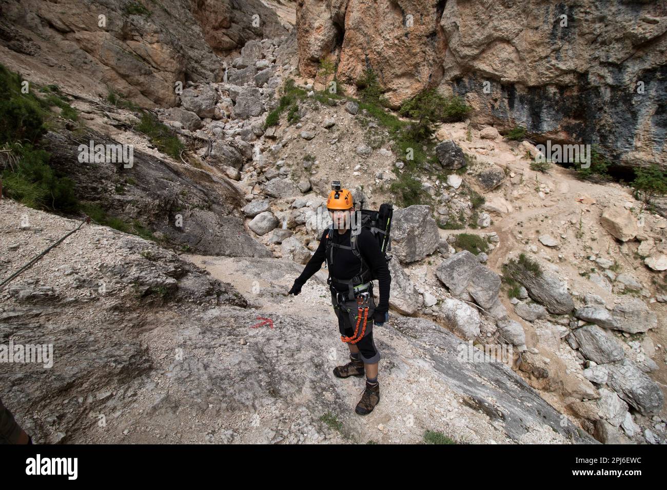 Tourist crossing the via ferrata trail with equipment in the dolomites ...