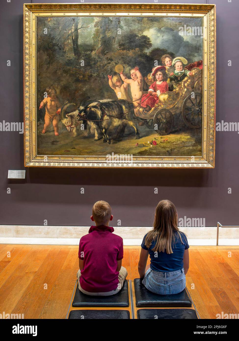 Two children with their backs to the photographer looking at a picture ...