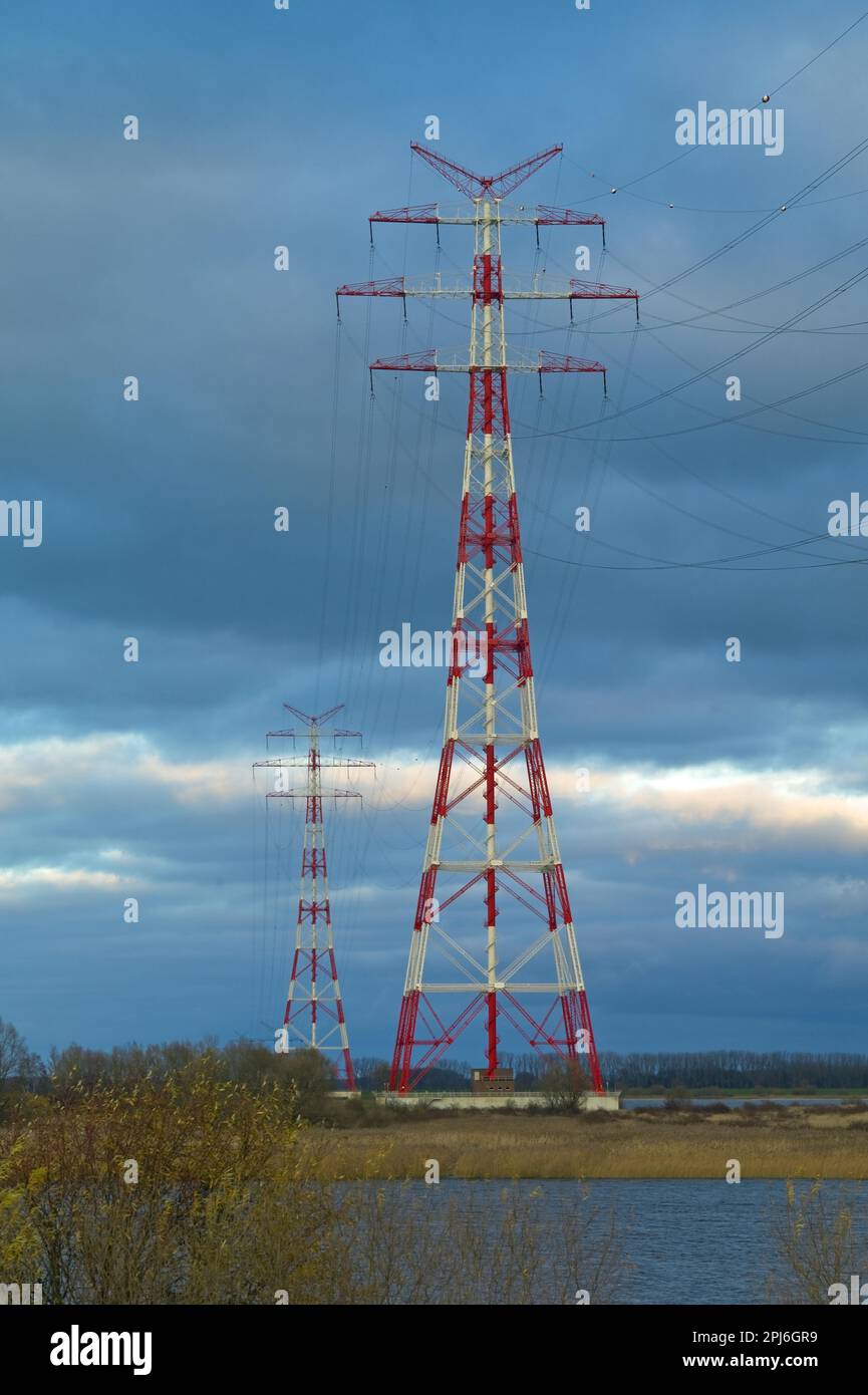 Red and white marked electricity pylons on the Lower Elbe near Stade, Elbe island Luehesand ...