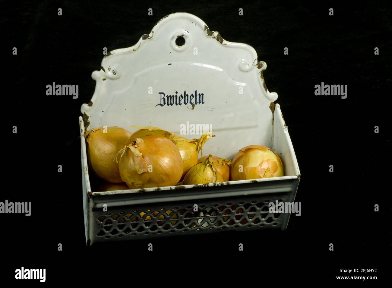 Onions in a metal onion box Stock Photo - Alamy