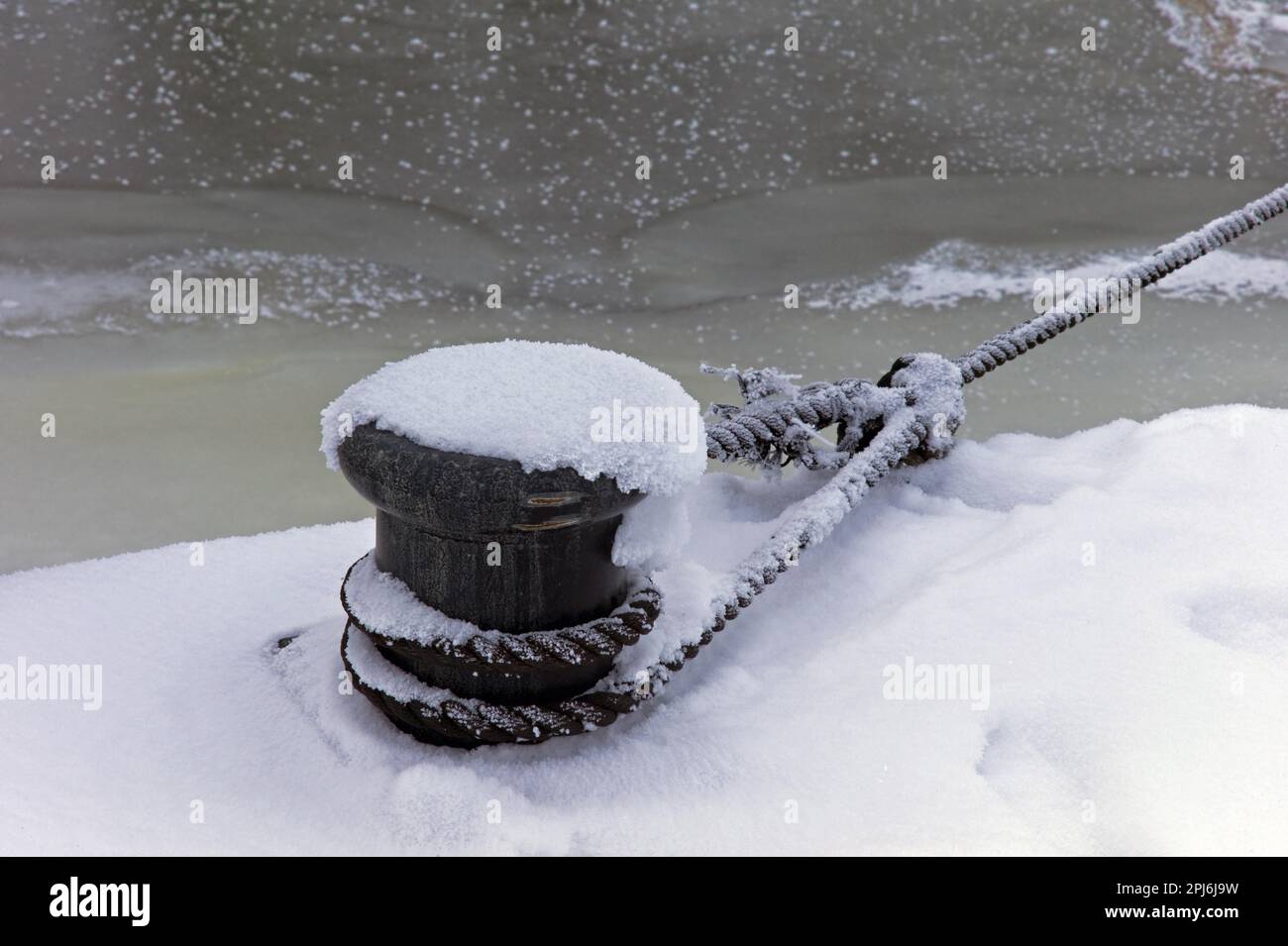 Snow-covered bollard at the harbour edge Stock Photo - Alamy
