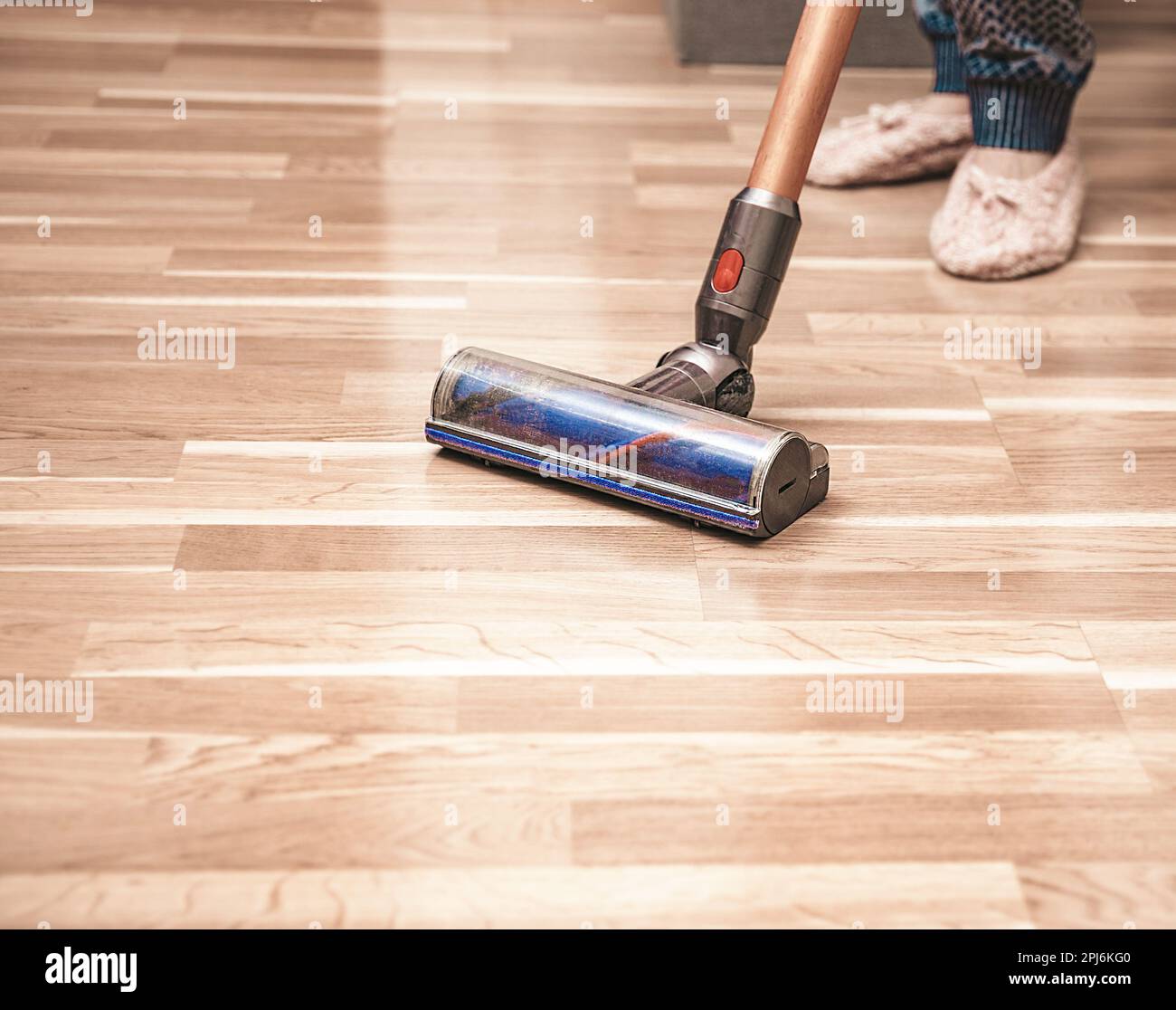 Woman cleaning floor using vacuum cleaner at home, house work, closeup ...