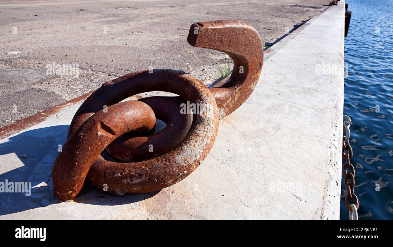 Old big and rusty mooring hook for ships on dock Stock Photo - Alamy