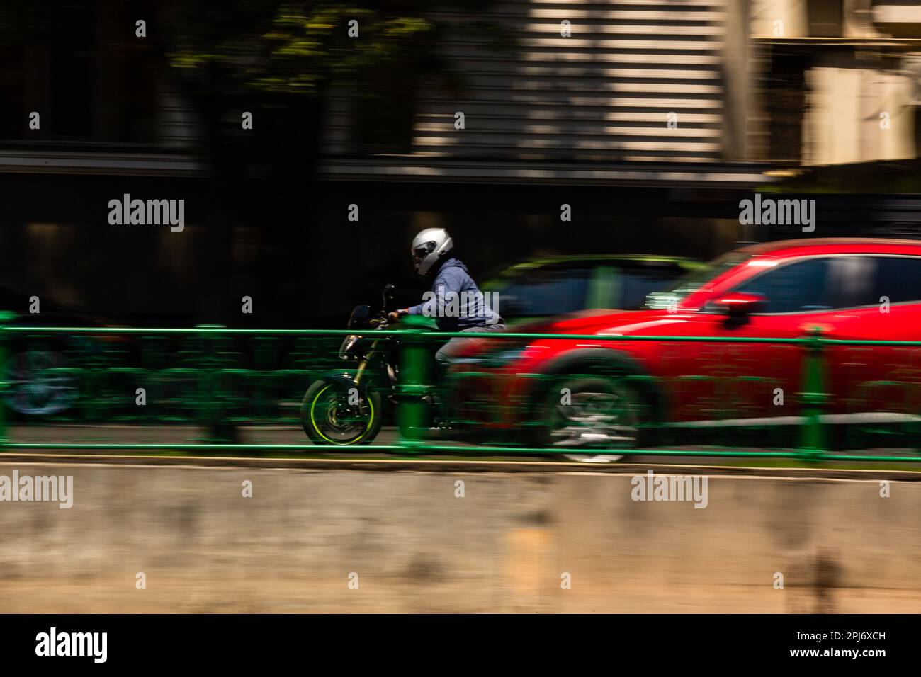 Biker on a motorcycle in traffic at rush hour in downtown area of the ...
