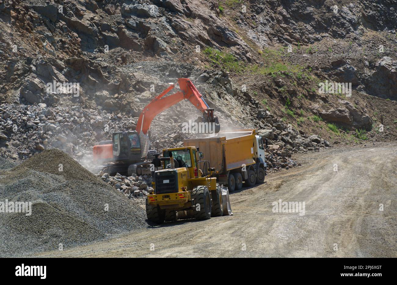 Construction work for the road. Excavator loads rock into truck. Road ...