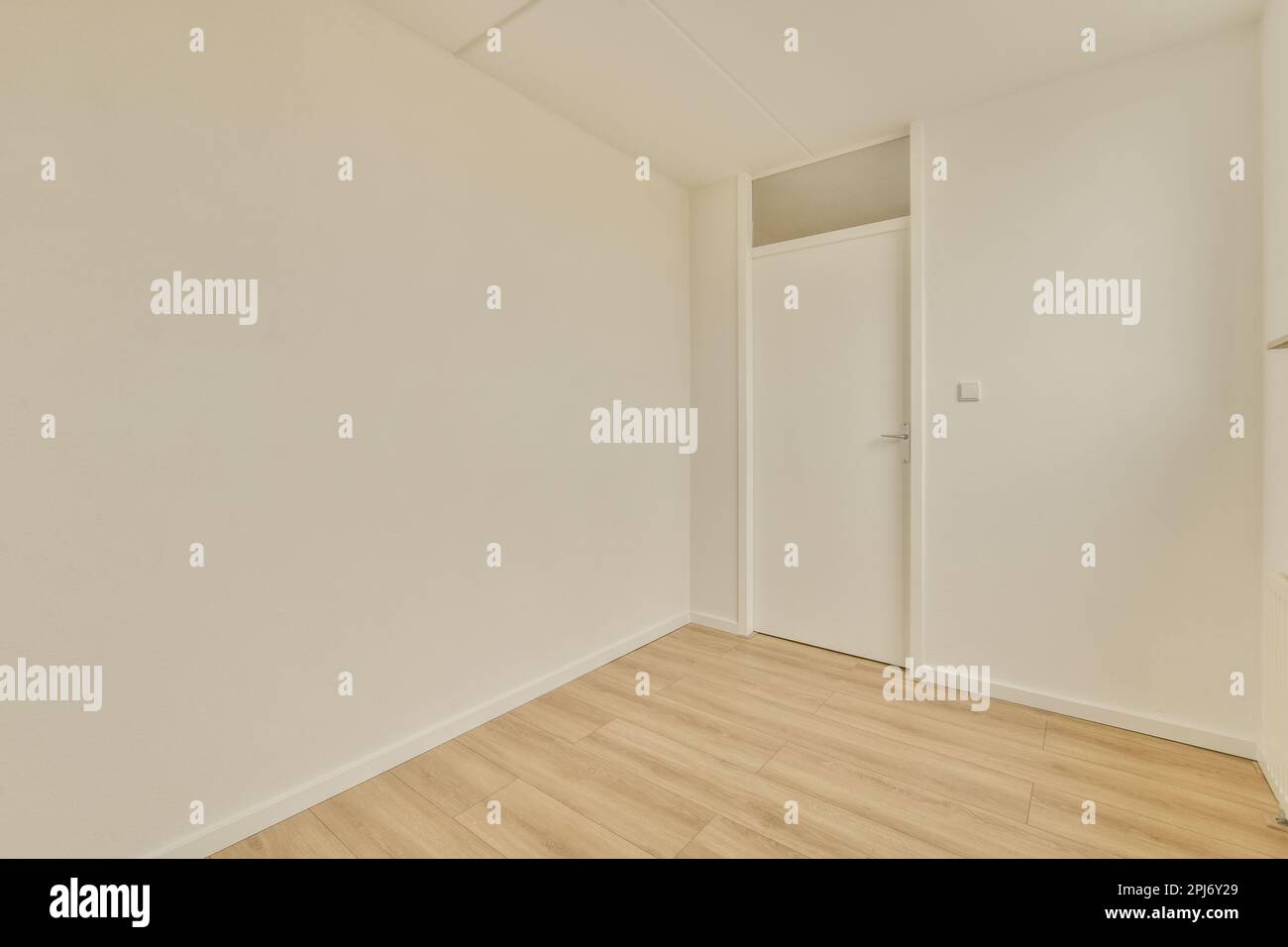 an empty room with white walls and wood flooring the door is open on ...