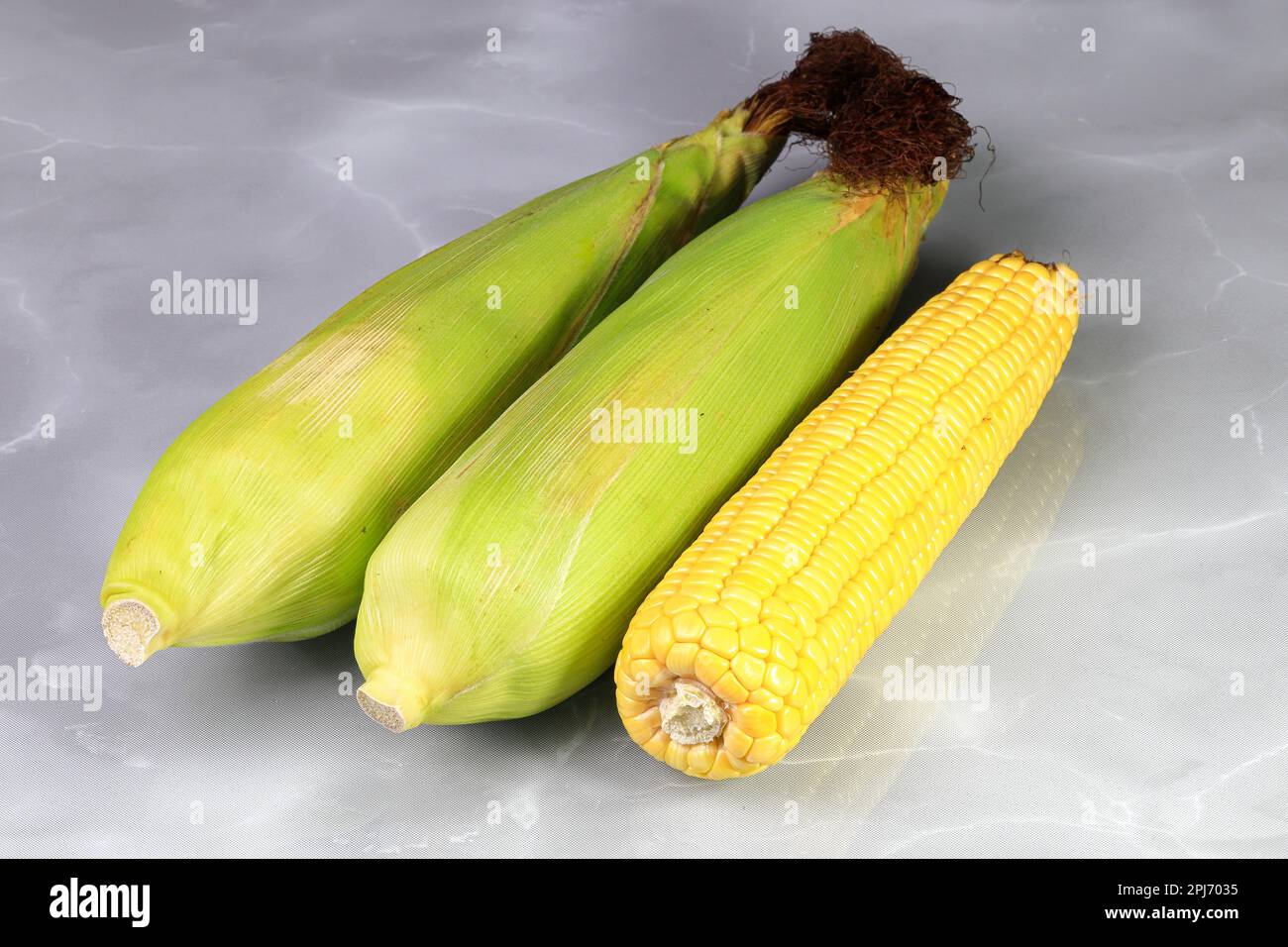 Fresh raw Corncobs or corn ears with green leaves isolated on ...