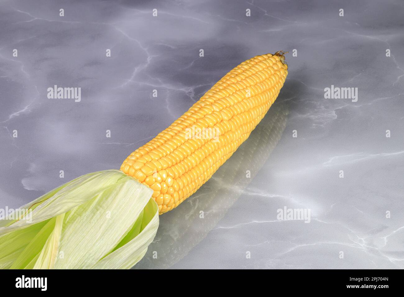 Fresh raw Corncob or corn ears with green leaves isolated on reflection ...