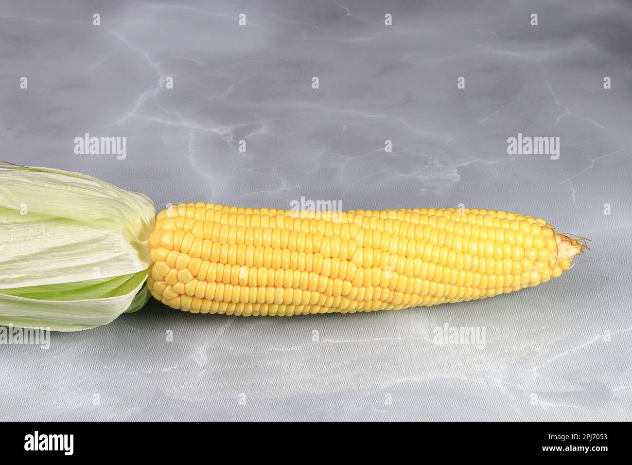 Fresh raw Corncob or corn ears with green leaves isolated on reflection ...