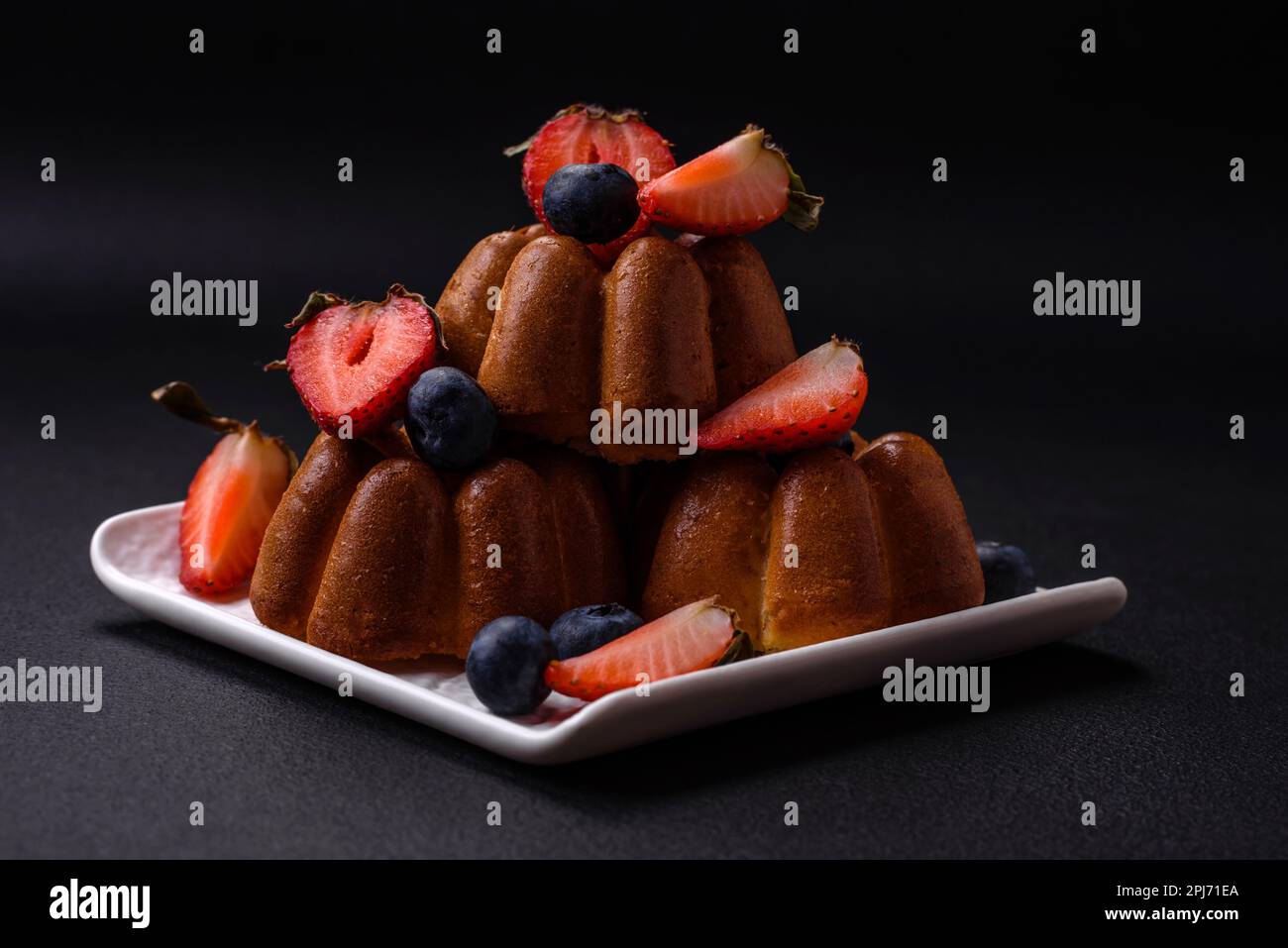 Delicious cupcakes or muffins with raisins and nuts, strawberries and ...