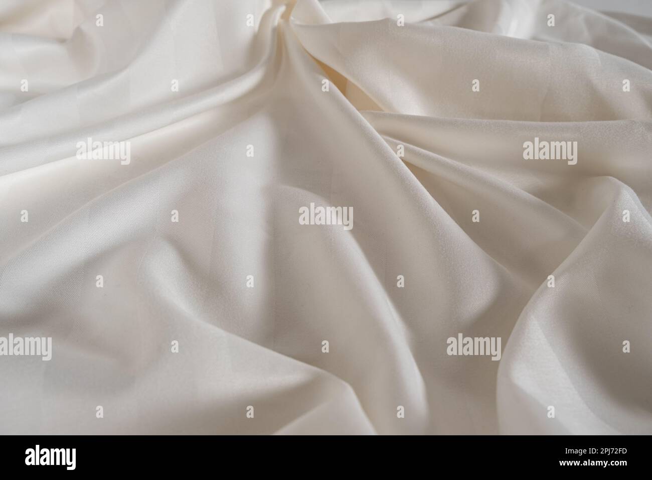 Satin crumpled fabric of light milky color, top view. Natural bed linen ...