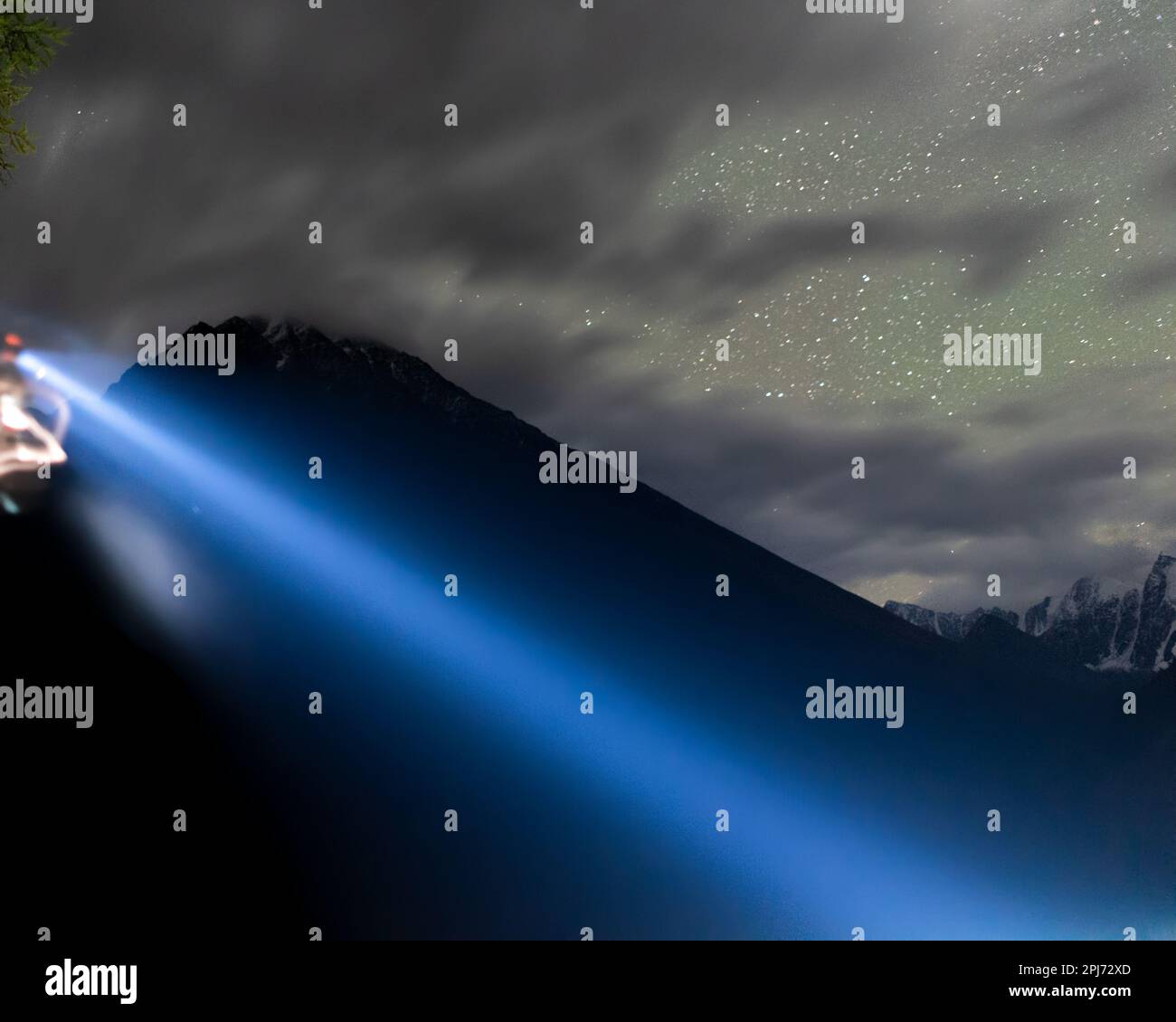 Abstract photo of a beam of a headlamp in the darkness of the mountains ...