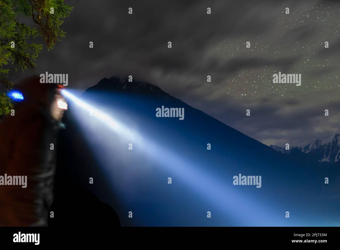 Abstract photo of a beam of a headlamp on a tourist girl in the ...