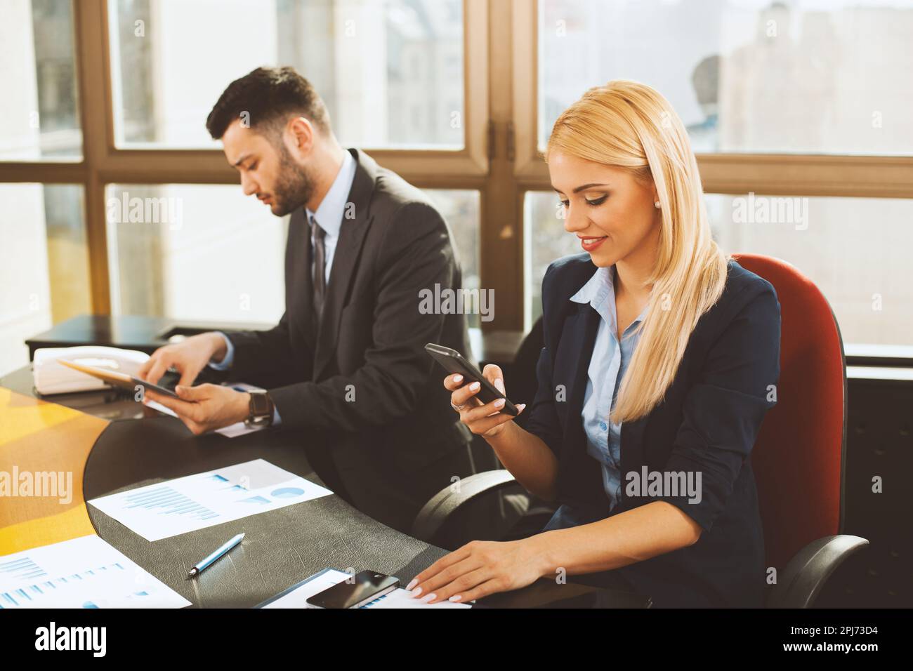 Young business woman typing a message on the phone in the office Stock ...