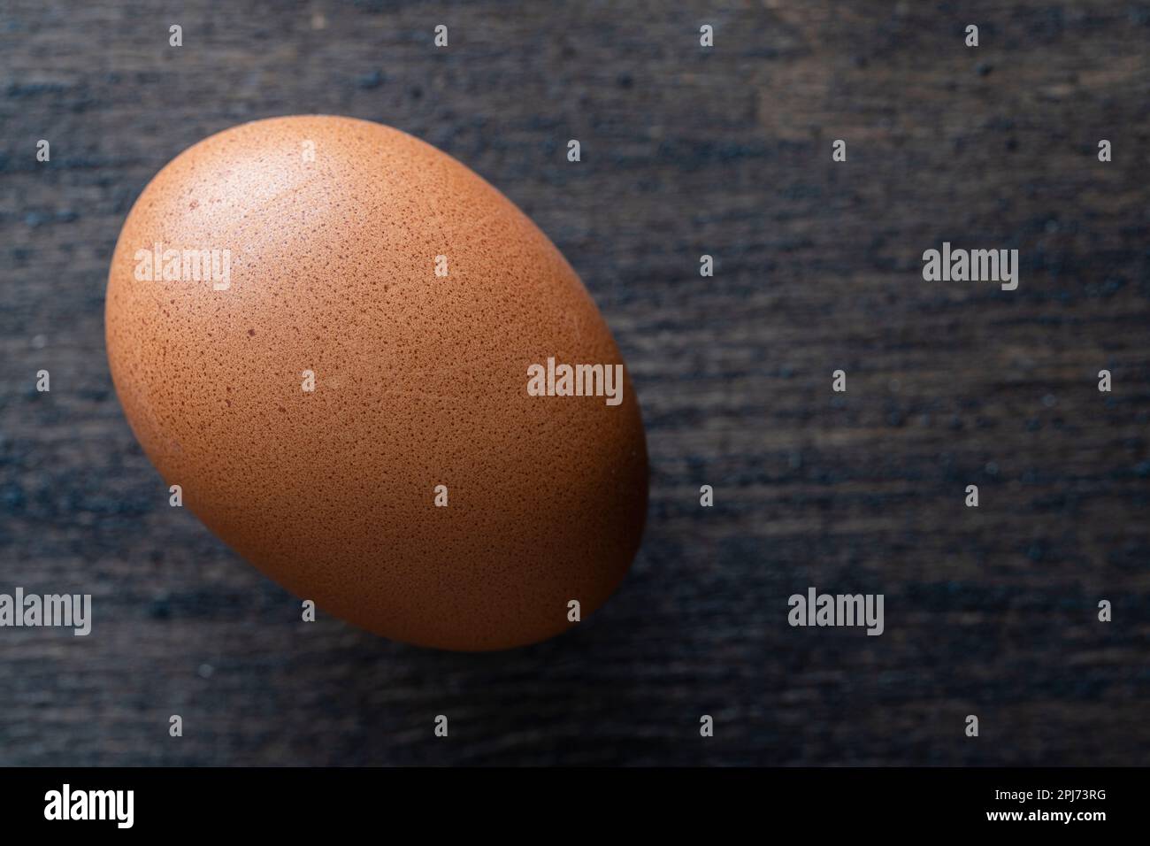 Fresh one brown egg in a wooden background from agriculture farm, close ...