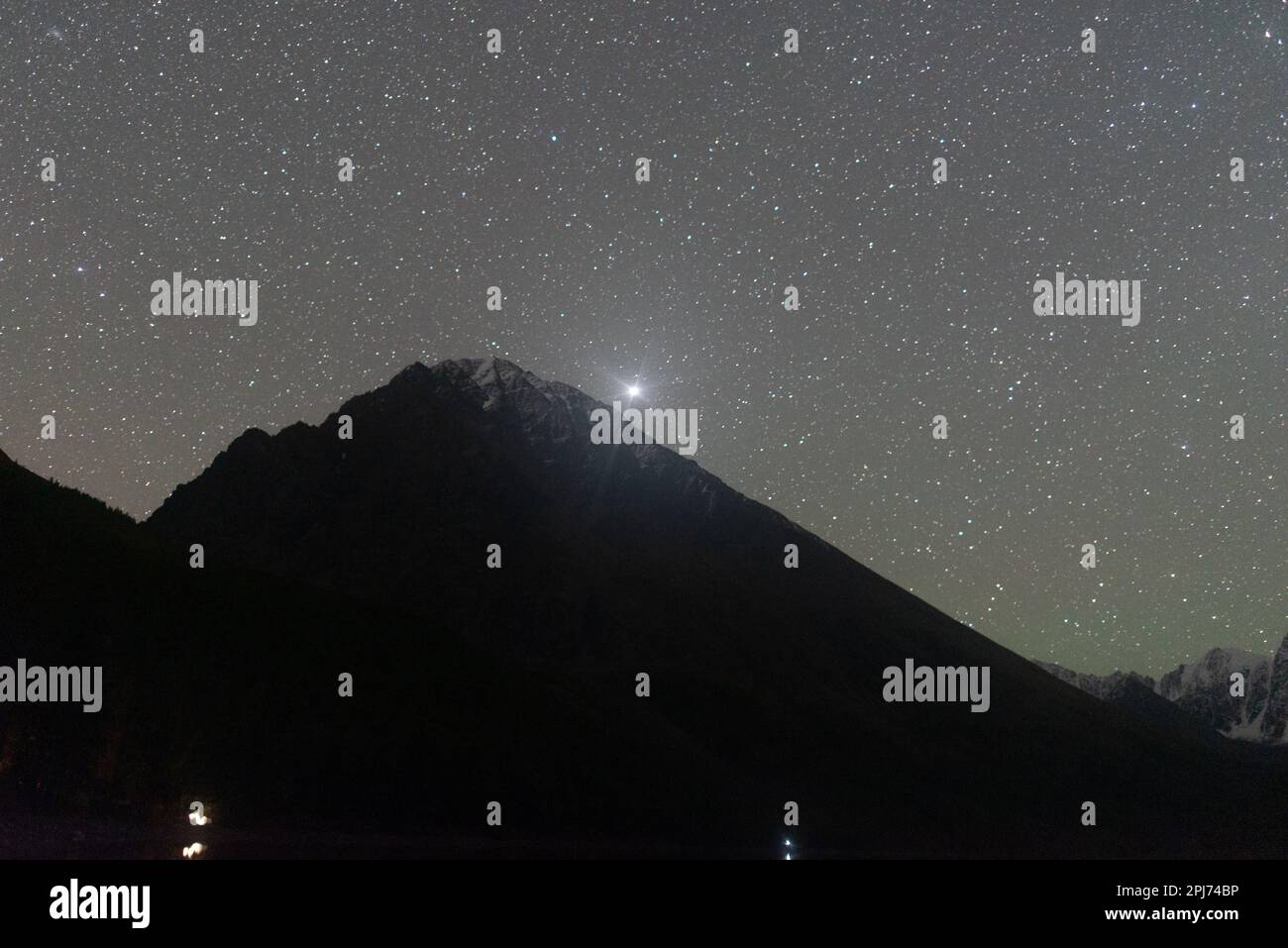 Bright star Sirius over a mountain with glaciers at night with the ...