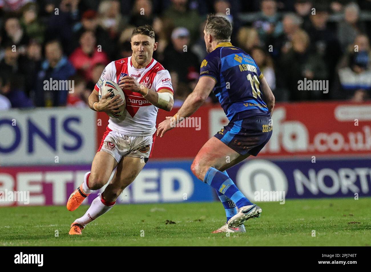 Tommy Makinson #2 of St Helens looks for a way past Matty Ashurst #11 ...