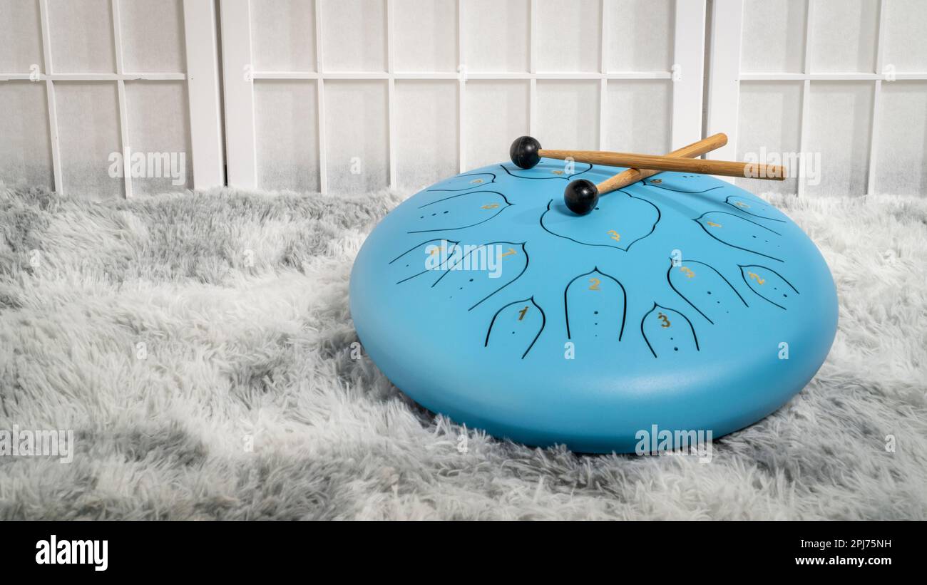 blue steel tongue drum with mallets on a fluffy rug Stock Photo - Alamy