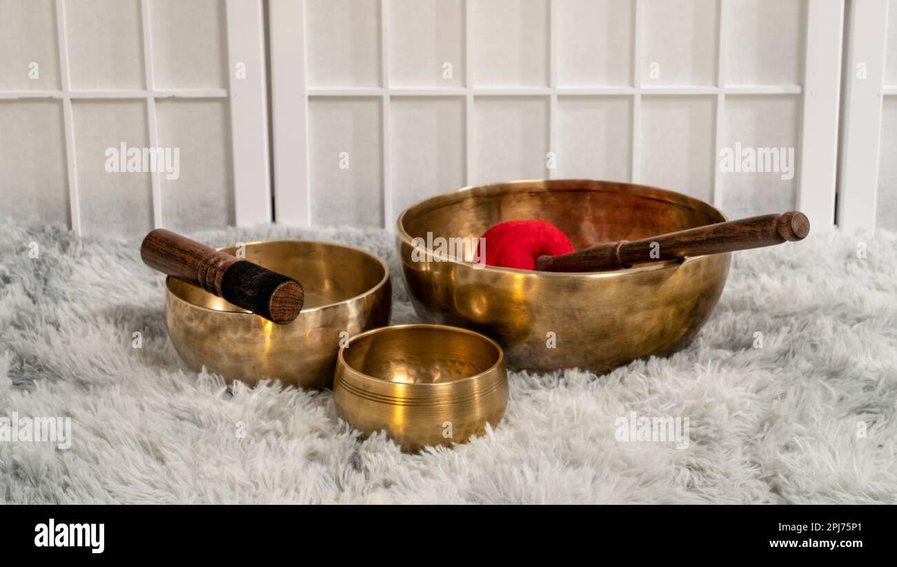 handmade Tibetan singing bowls with mallets on a fluffy rug, sound ...