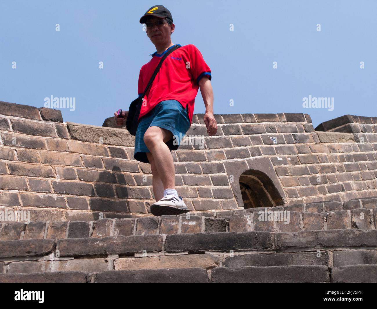 Chinese man walking along a restored renewed stretch of the Great Wall ...