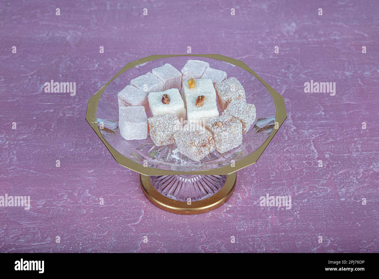 Turkish delight, Turkish delight, on a crystal glass plate. Pink wooden ...
