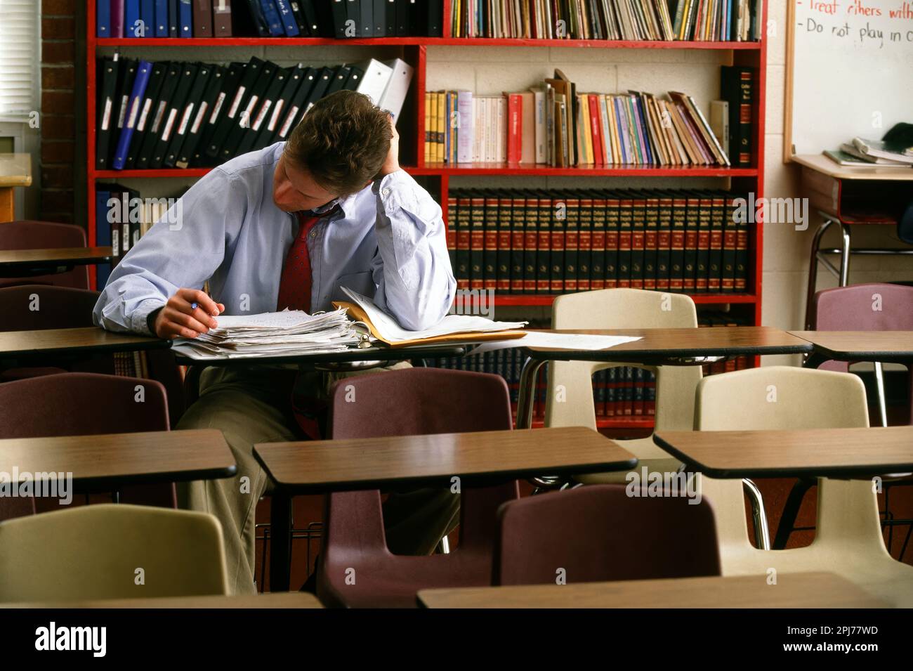 A hard-working male Caucasian Elementary school teacher sitting add a ...