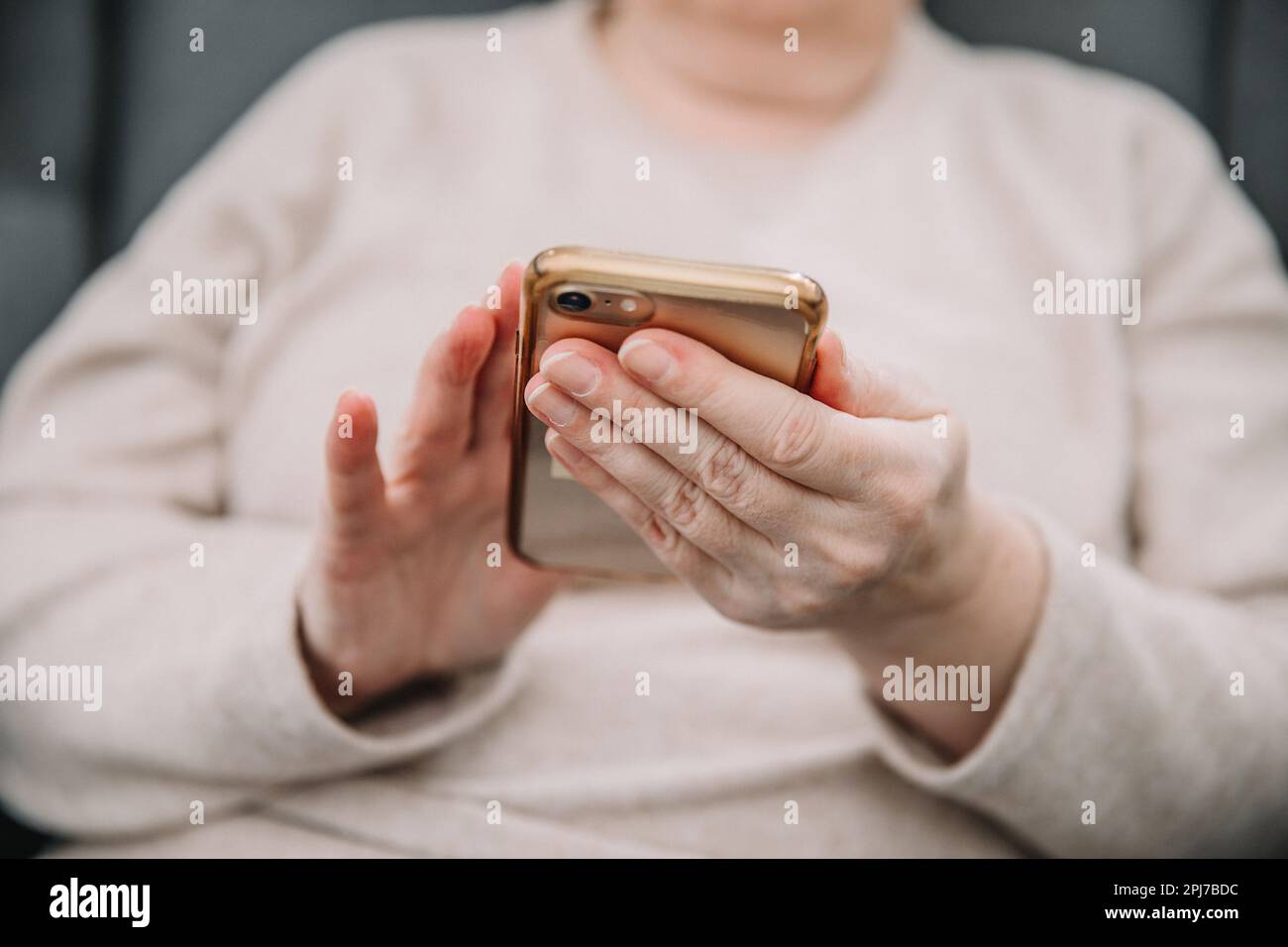 An elderly woman holds and uses a smartphone in her hand, a smartphone ...