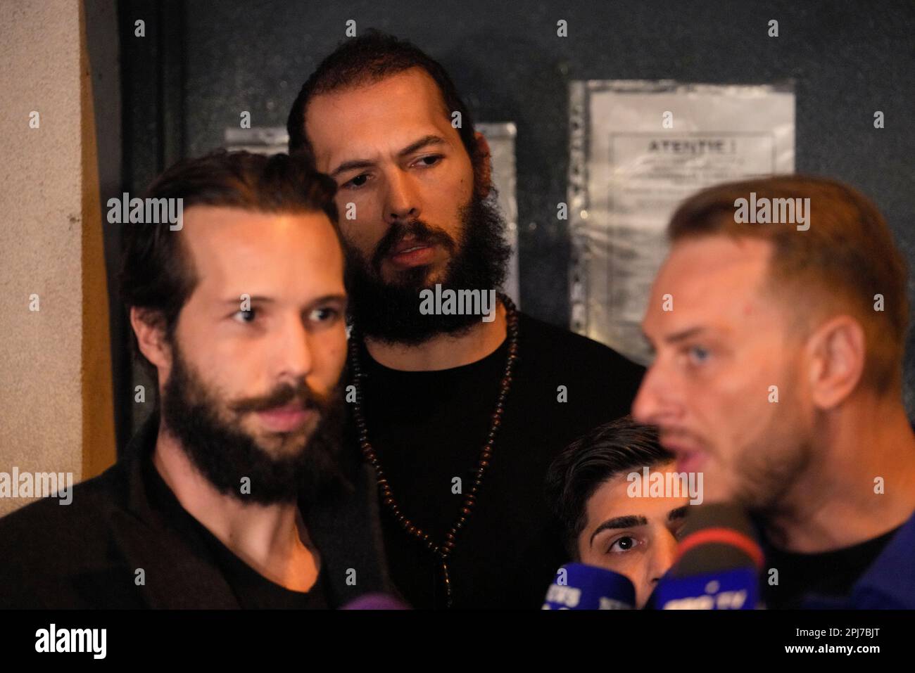 Andrew Tate, center, and his brother Tristan stand outside a detention ...