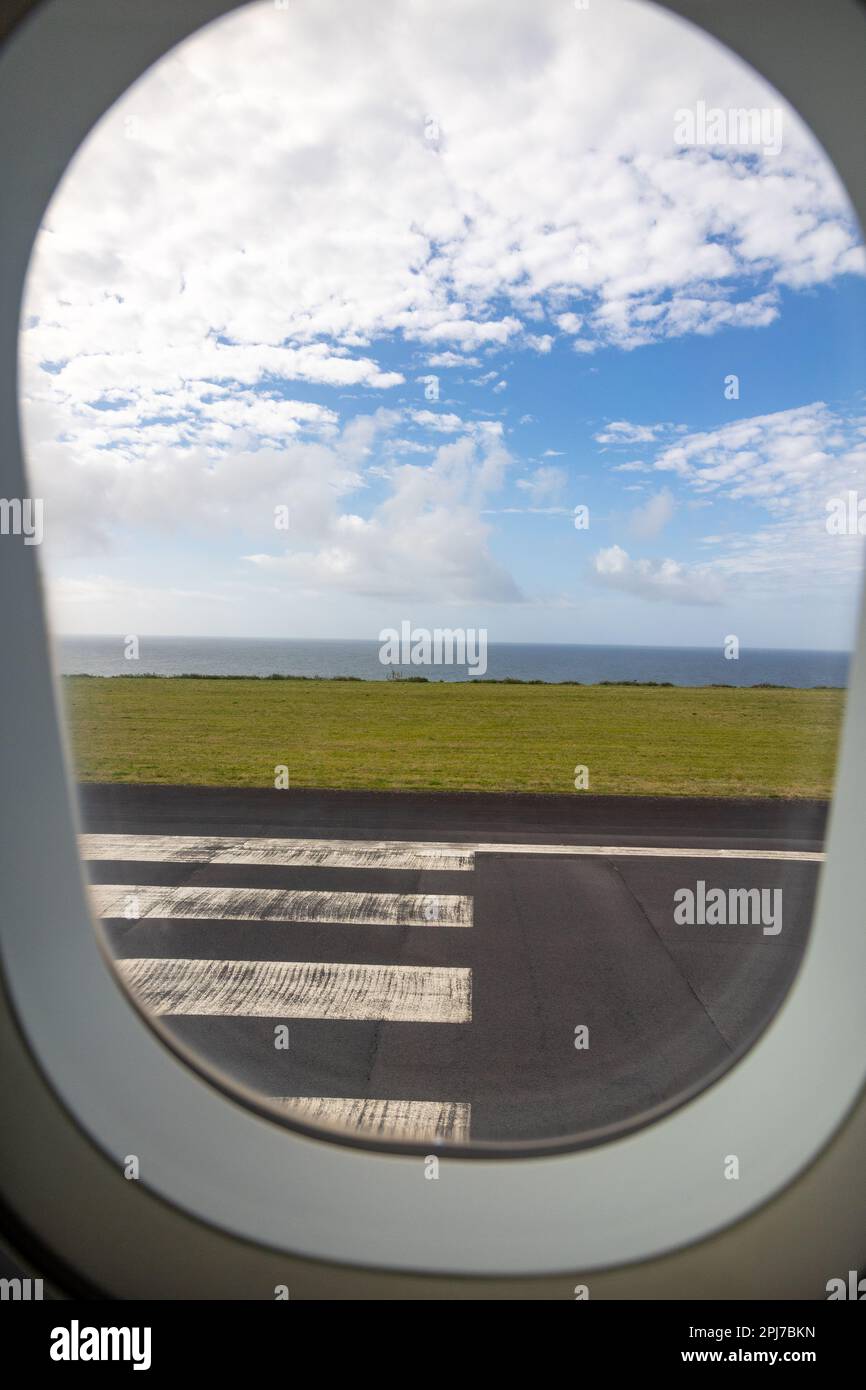 View from plane window, ocean, clouds and runway Stock Photo - Alamy