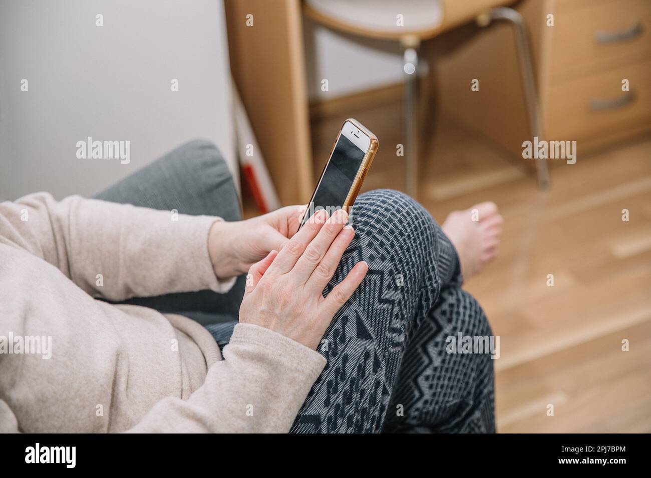 An elderly woman holds and uses a smartphone in her hand, a smartphone ...