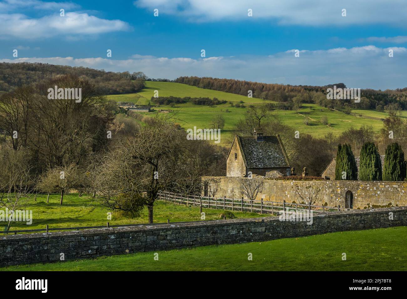 Medieval stone build cottage and stone walls in the green British ...