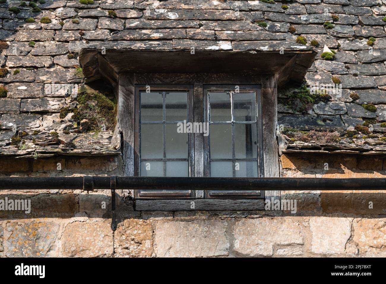 Detail of old traditional windows and roof tiles of stone built ...