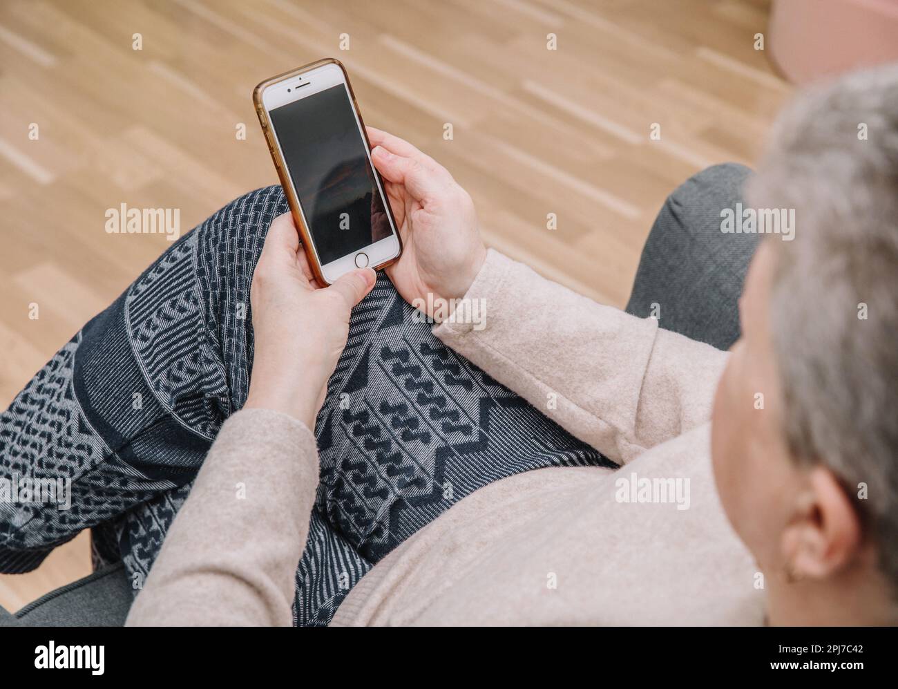 An elderly woman holds and uses a smartphone in her hand, a smartphone ...