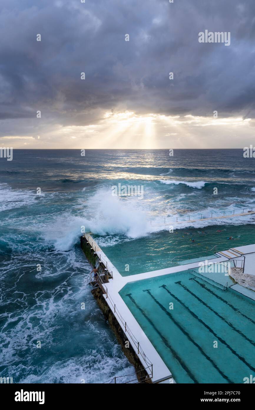 Emerging light rays beaming onto the rockpool in Bondi Beach, Sydney ...