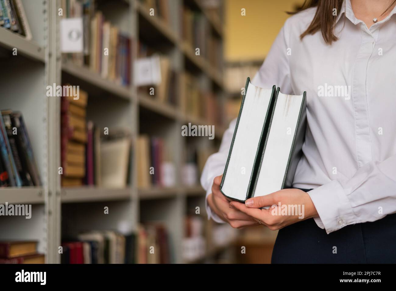 Close-up of female hands with books in public library Stock Photo - Alamy