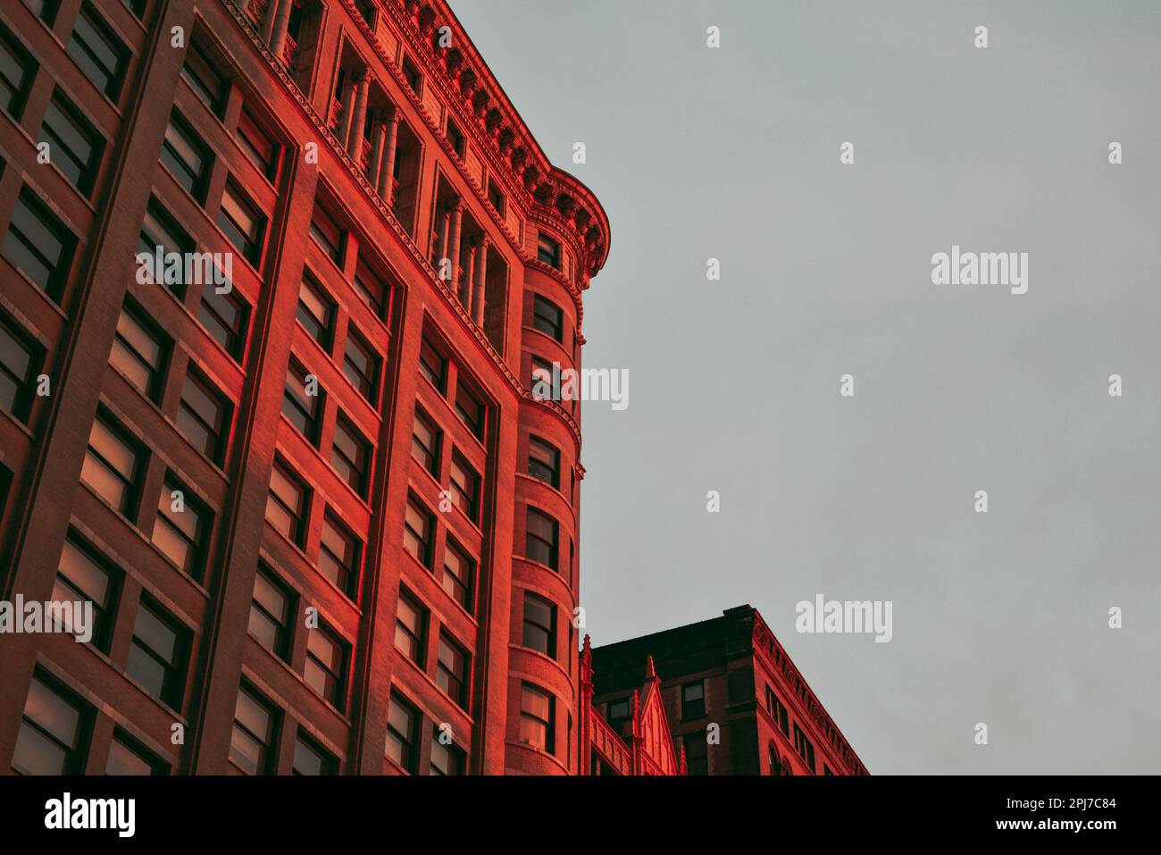 A high-angle shot of a cityscape featuring several red buildings, one ...