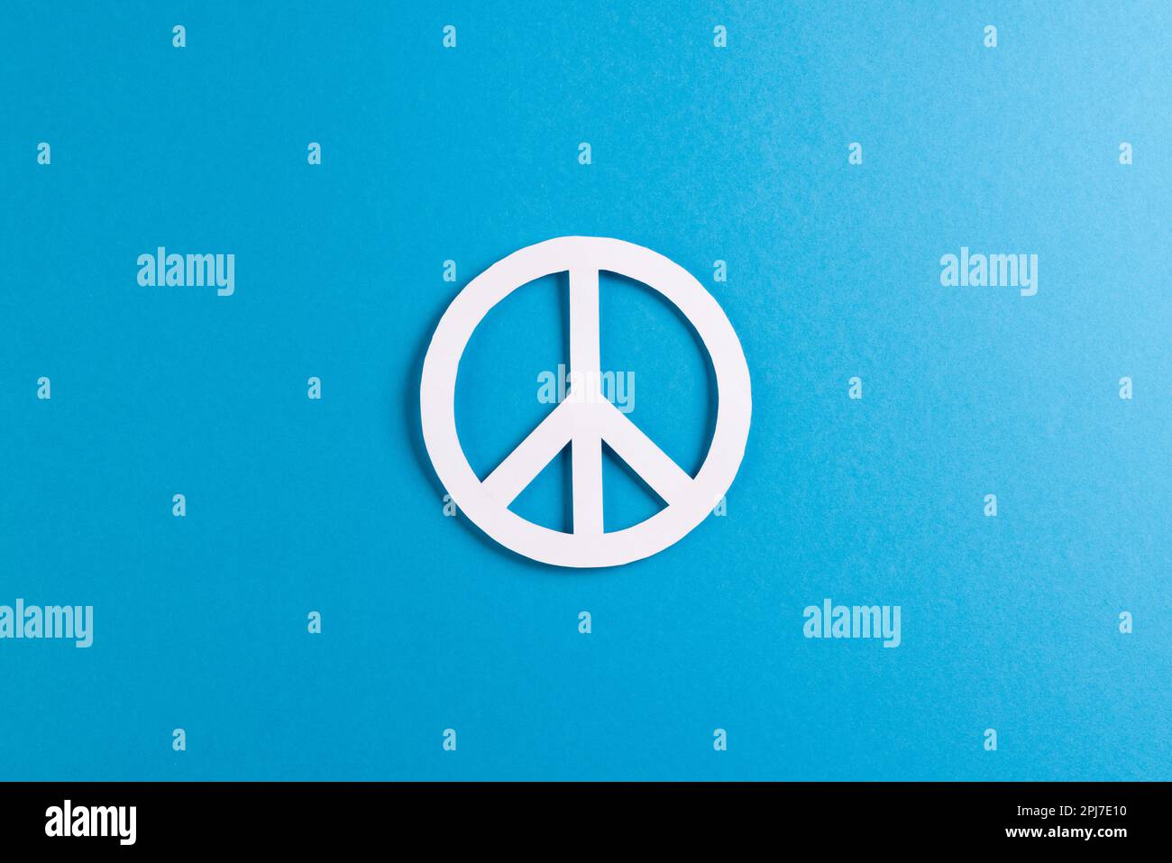 High angle view of white peace sign with copy space on blue background ...