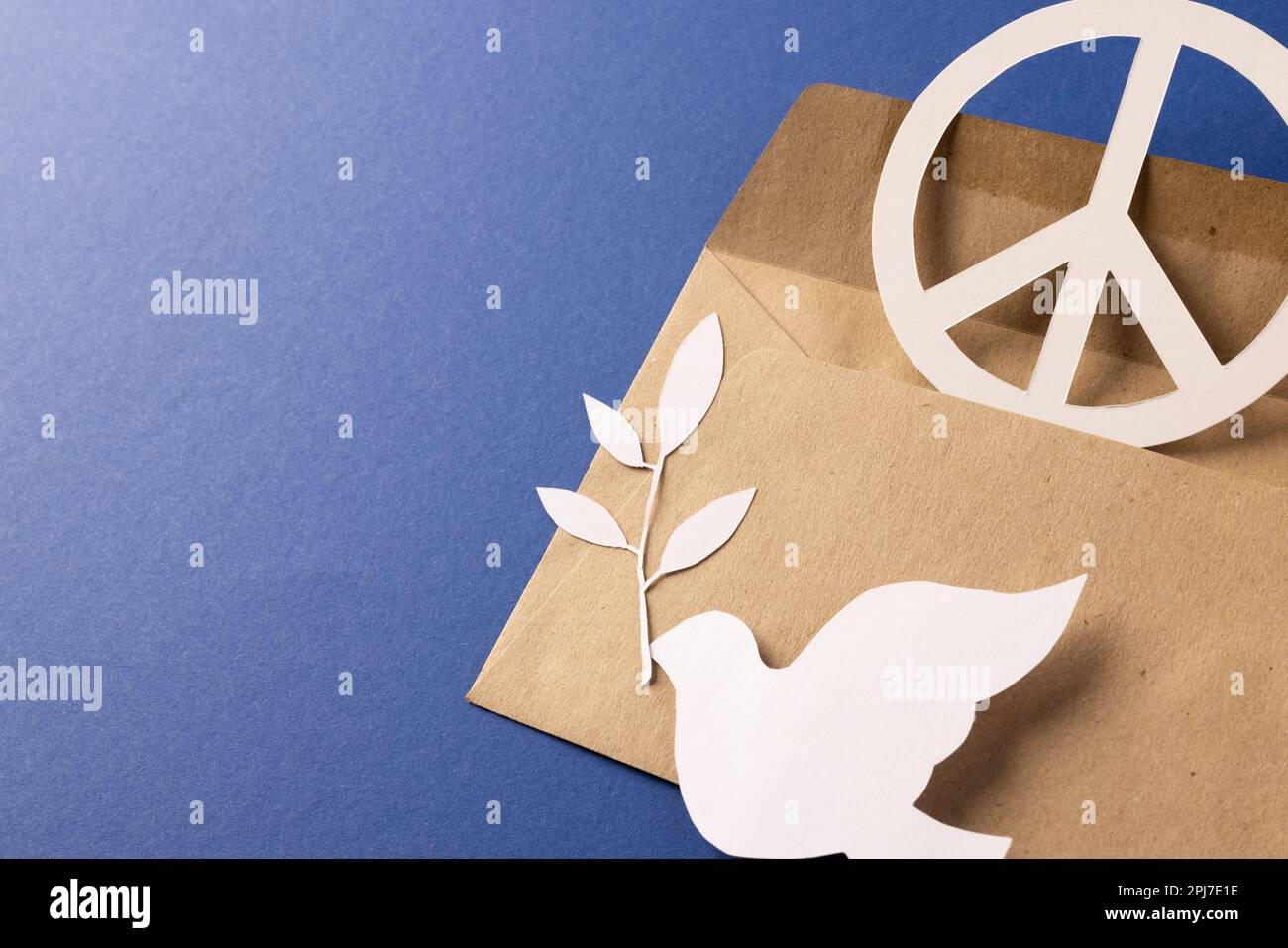 High angle view of white peace sign, white dove and envelope with copy ...