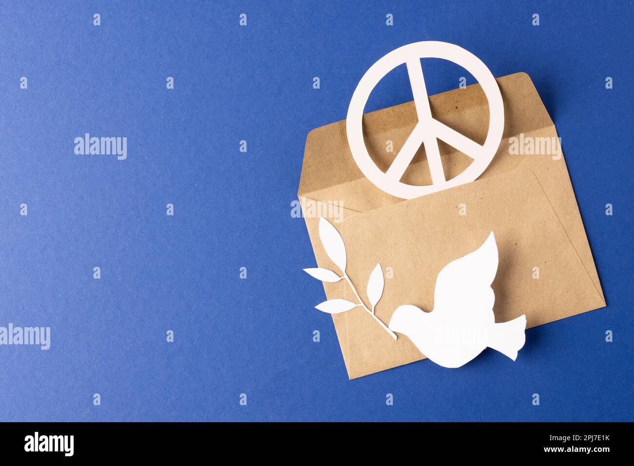High angle view of white peace sign, white dove and envelope with copy ...