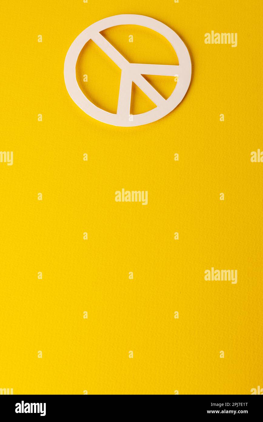 High angle view of white peace sign with copy space on yellow ...