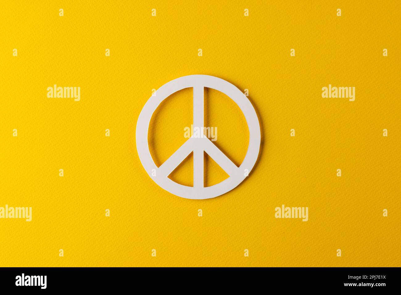 High angle view of white peace sign with copy space on yellow ...