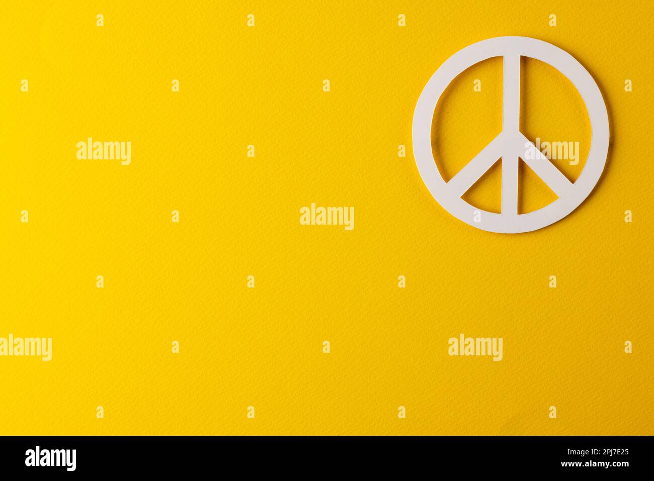 High angle view of white peace sign with copy space on yellow ...