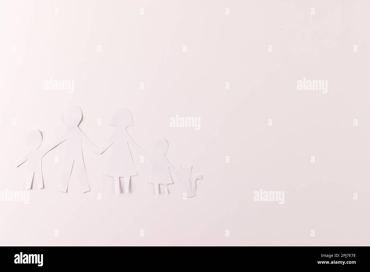 White paper cut out of family with two children and cat and copy space ...