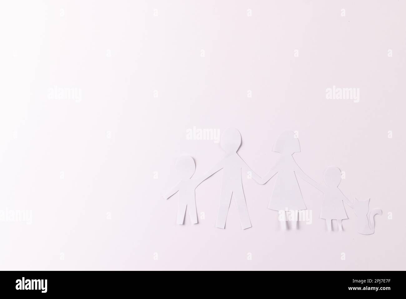 White paper cut out of family with two children and cat and copy space ...