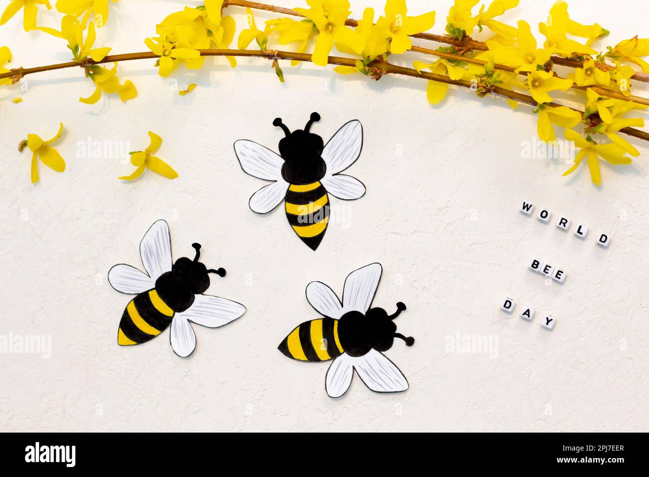 Handmade paper bees with Forsythia flowers on white background. World ...