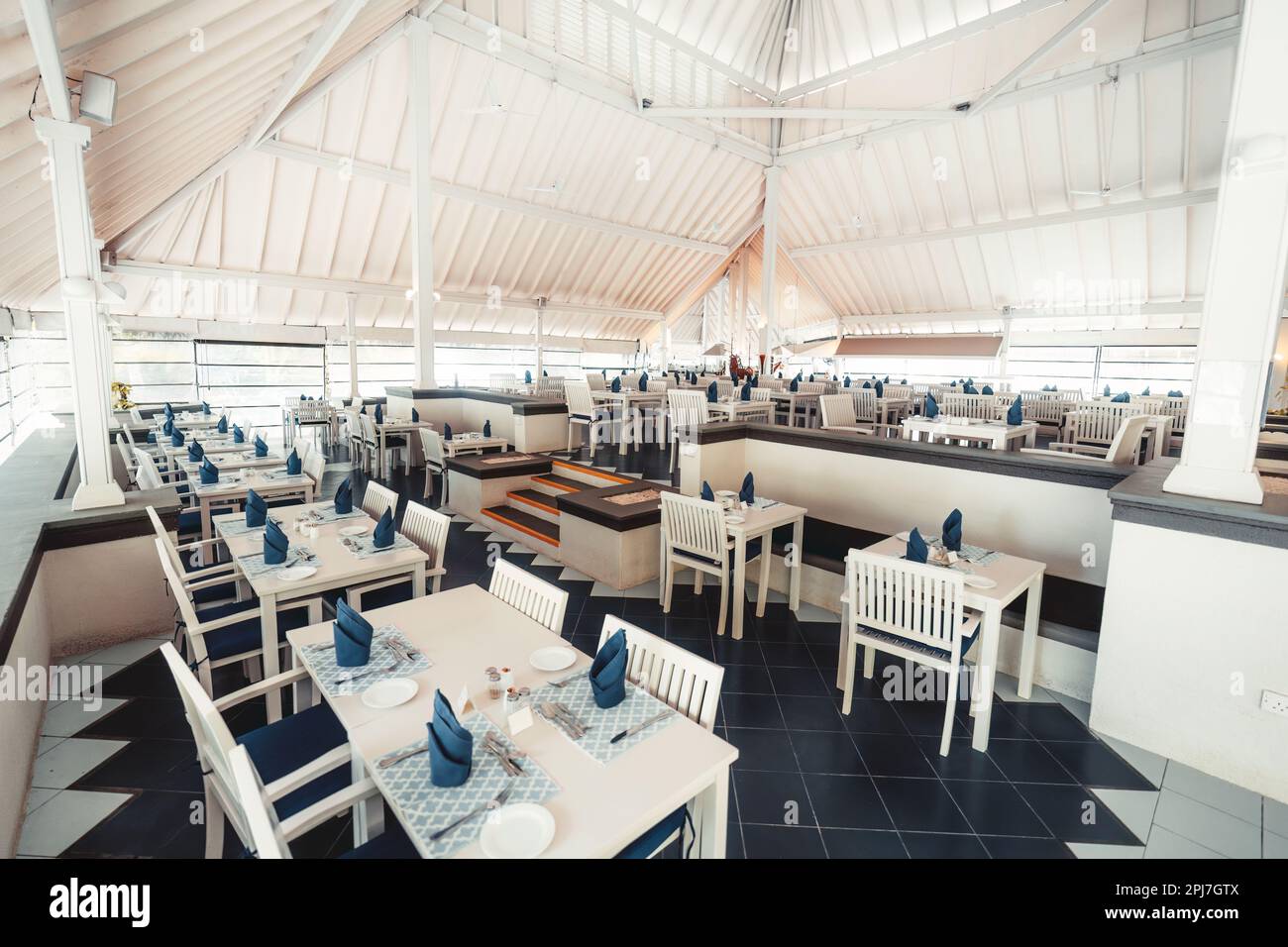 Wide-angle shot of a serene Maldivian restaurant divided into two ...